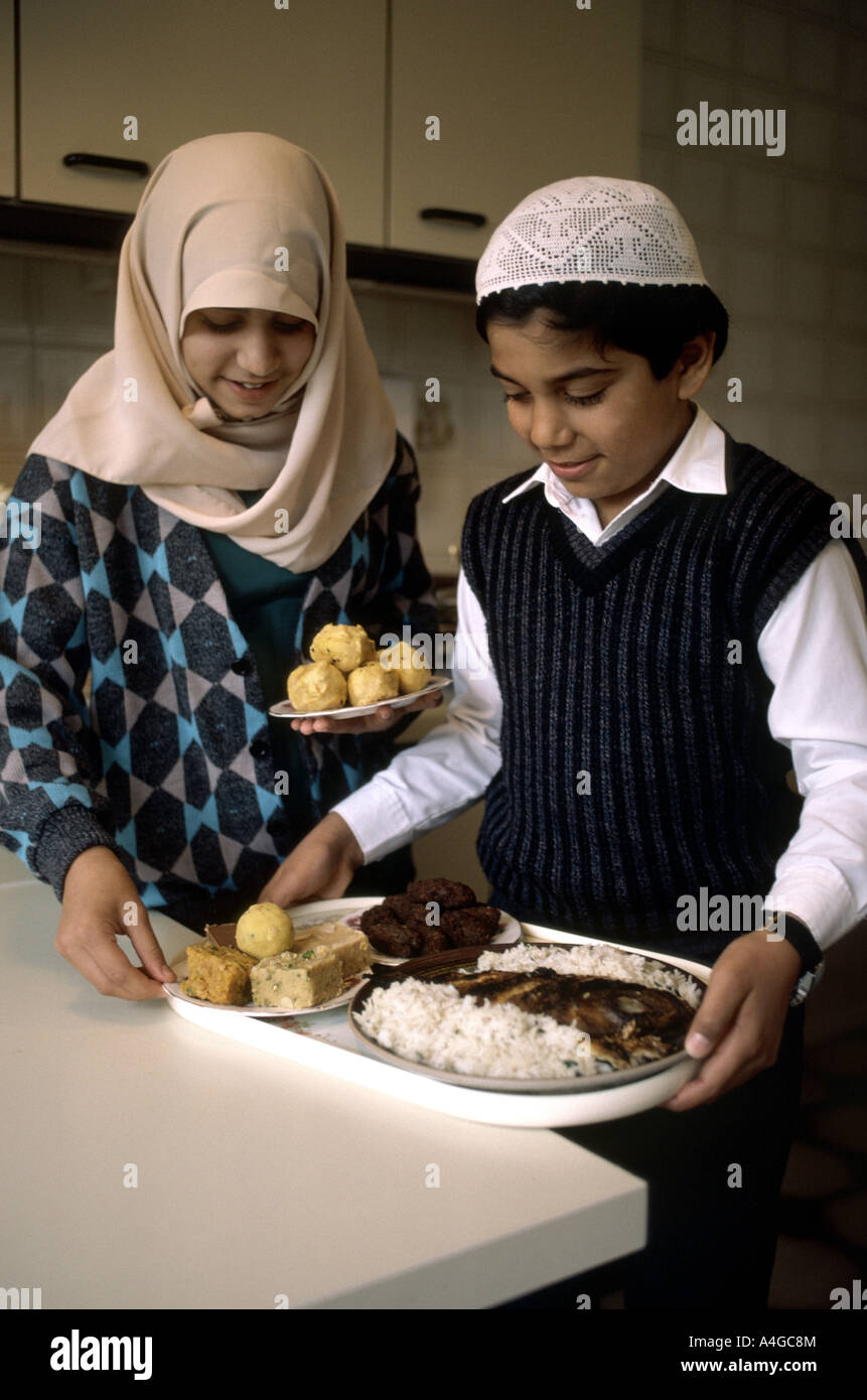 At the end of Ramadan young muslim brother and sister prepare meal to ...