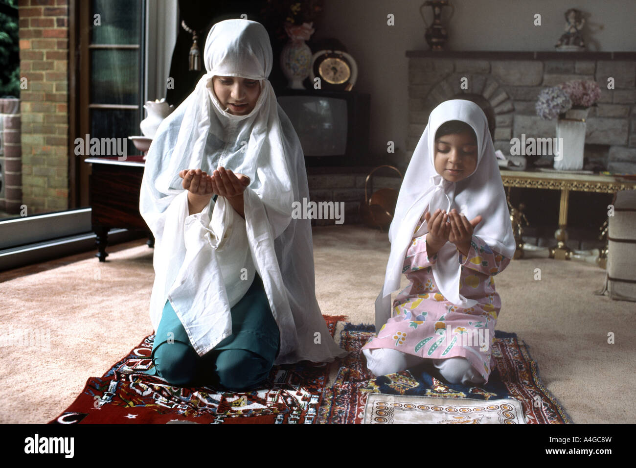 Muslim sisters praying in their home Stock Photo - Alamy