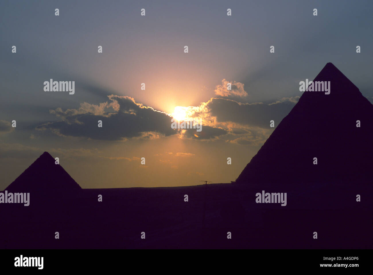 Sun setting over pyramids at Giza, outside of Cairo, Egypt Stock Photo ...