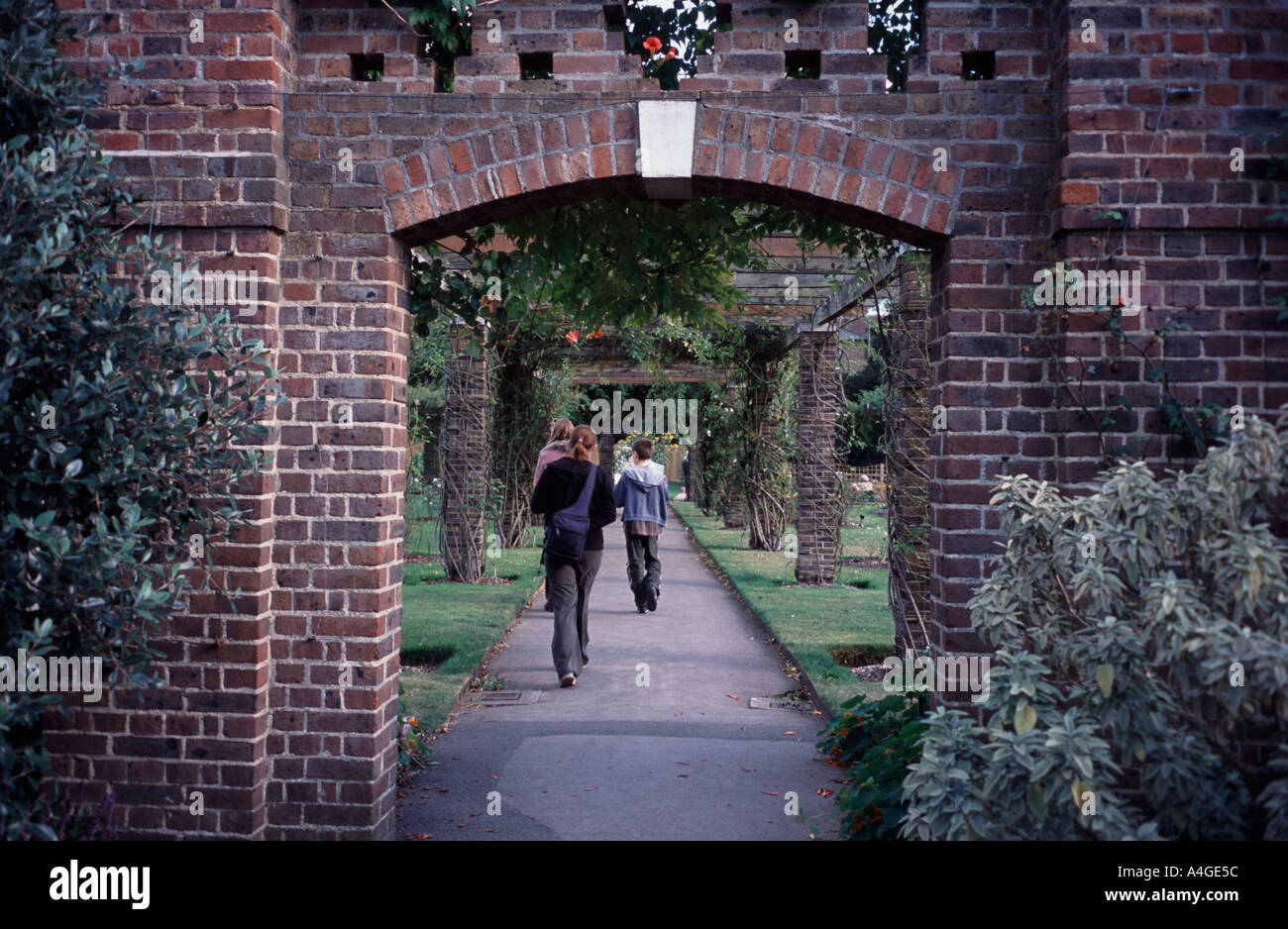 People walking through a covered, arched walkway Kew Gardens Surrey ...