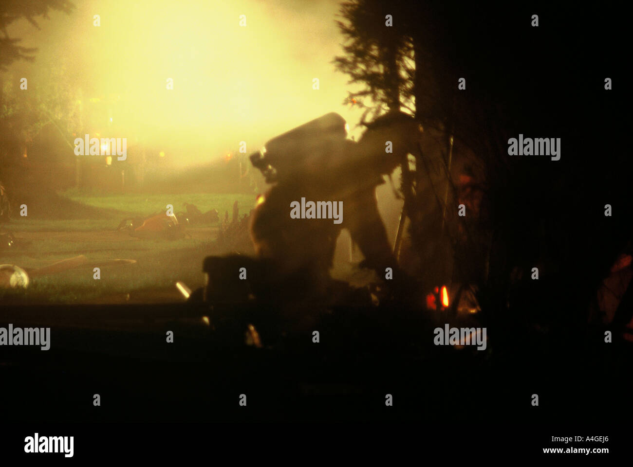 Silhouette of a fire fighter bending over at the front corner of house ...