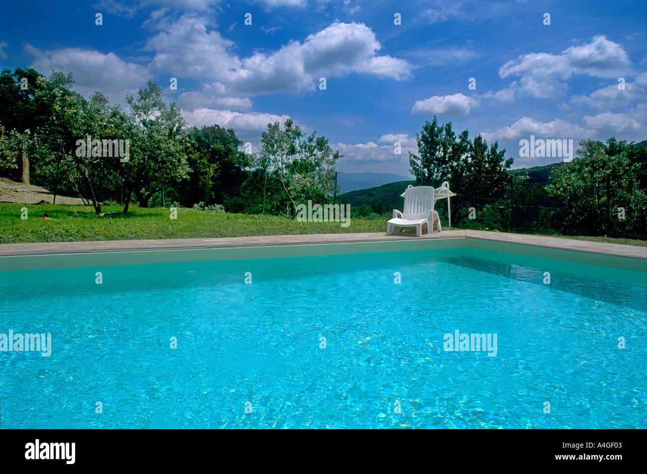 swimming pool with an empty deck chair Stock Photo - Alamy
