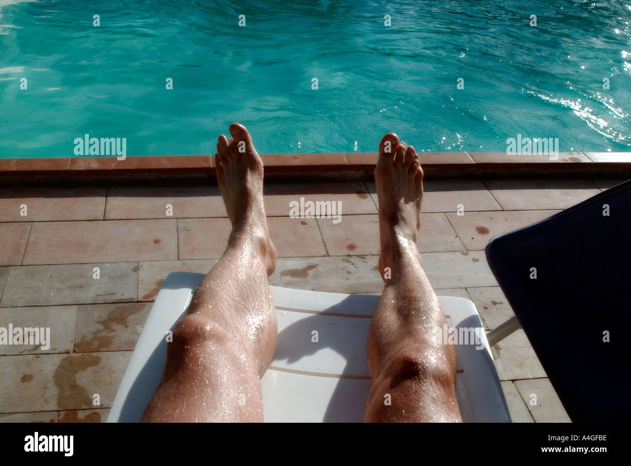 man sunbathing at pool side Stock Photo - Alamy