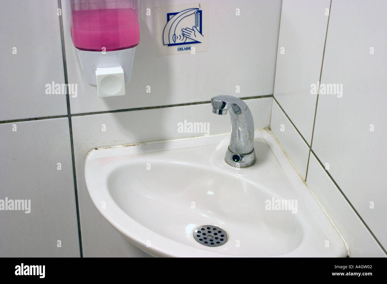 clean sink with pink soap dispenser Stock Photo - Alamy