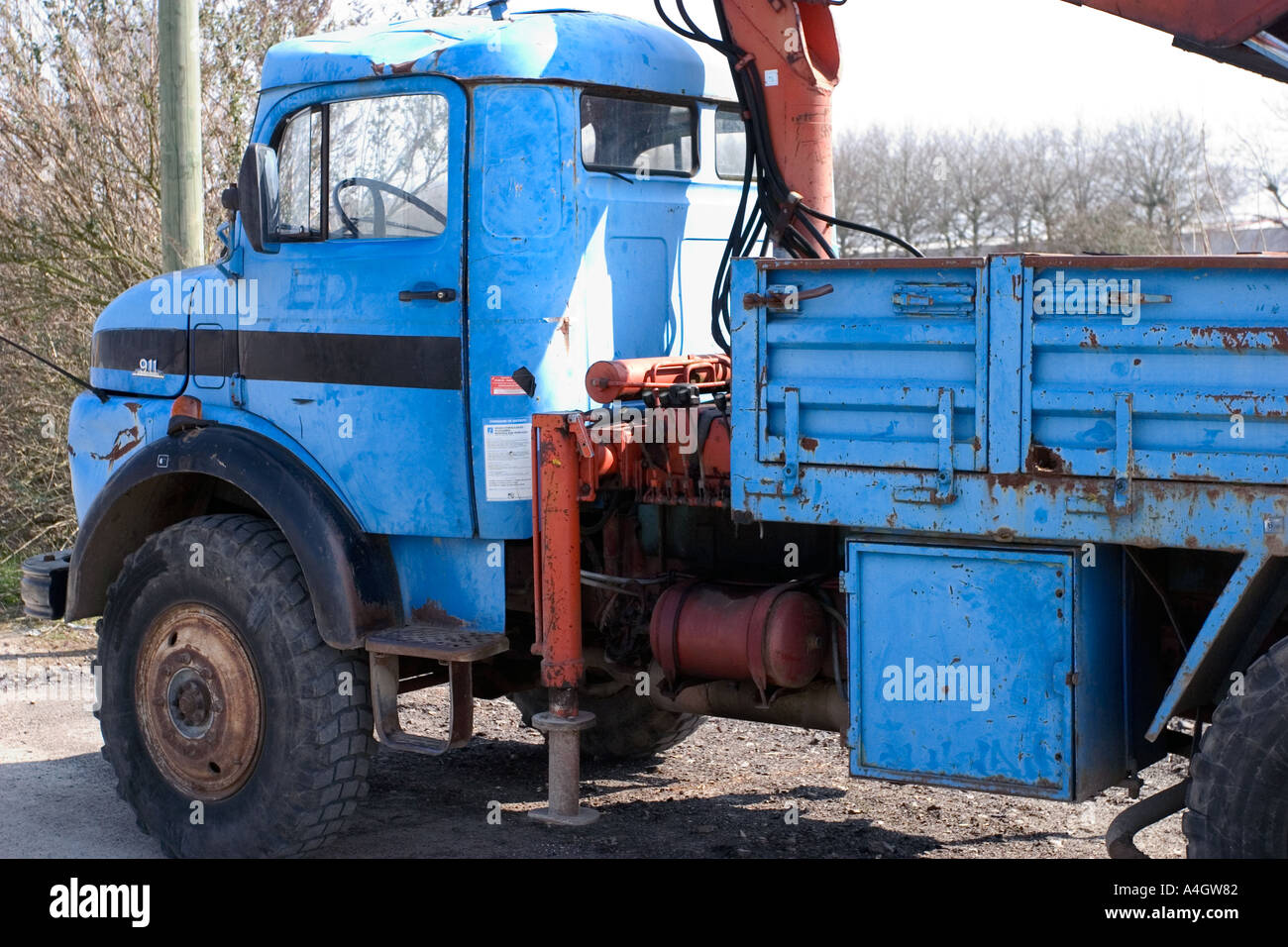 old blue mercedes truck with crane in back abandoned Stock Photo - Alamy