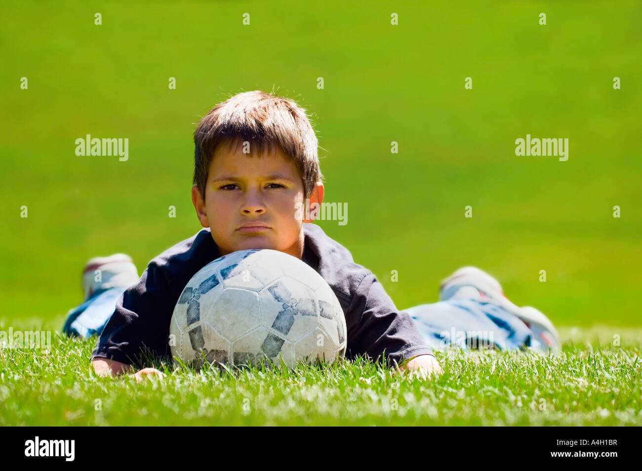 Boy resting with soccer ball Stock Photo - Alamy