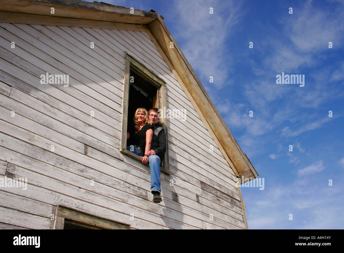 Couple sitting in window Stock Photo - Alamy