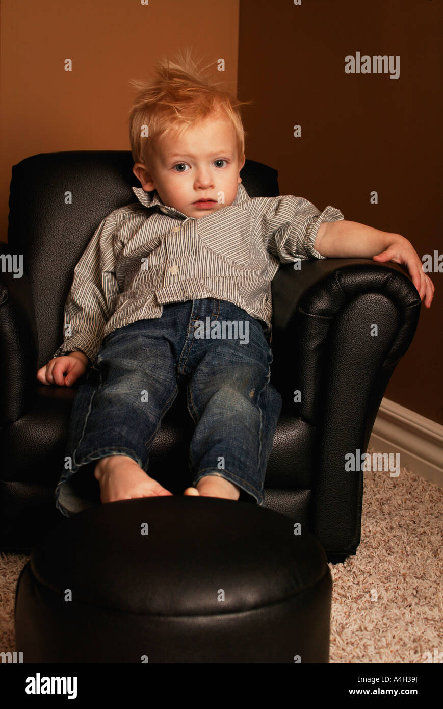 Boy sitting in a chair Stock Photo - Alamy