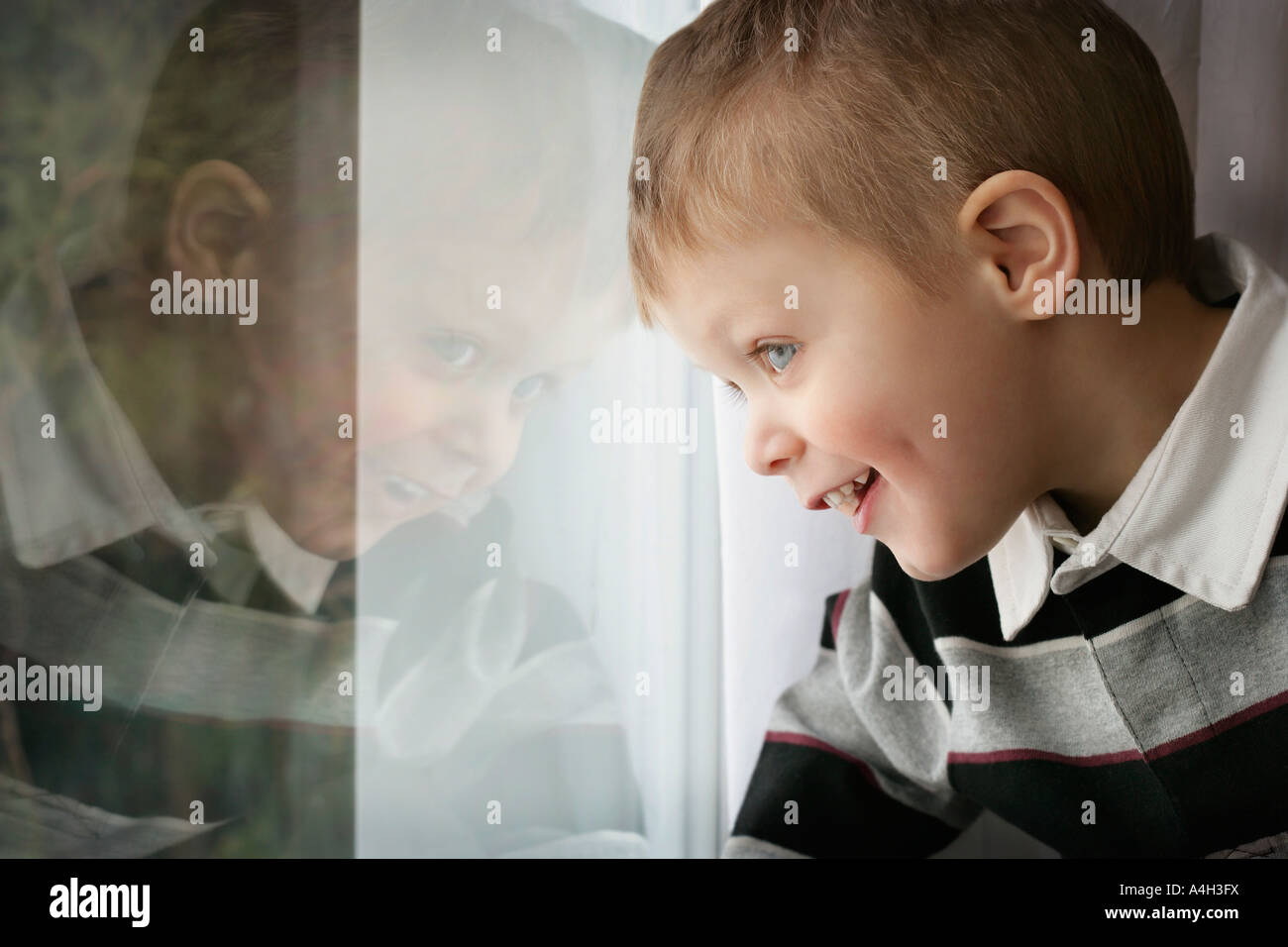 Boy looking out the window Stock Photo - Alamy