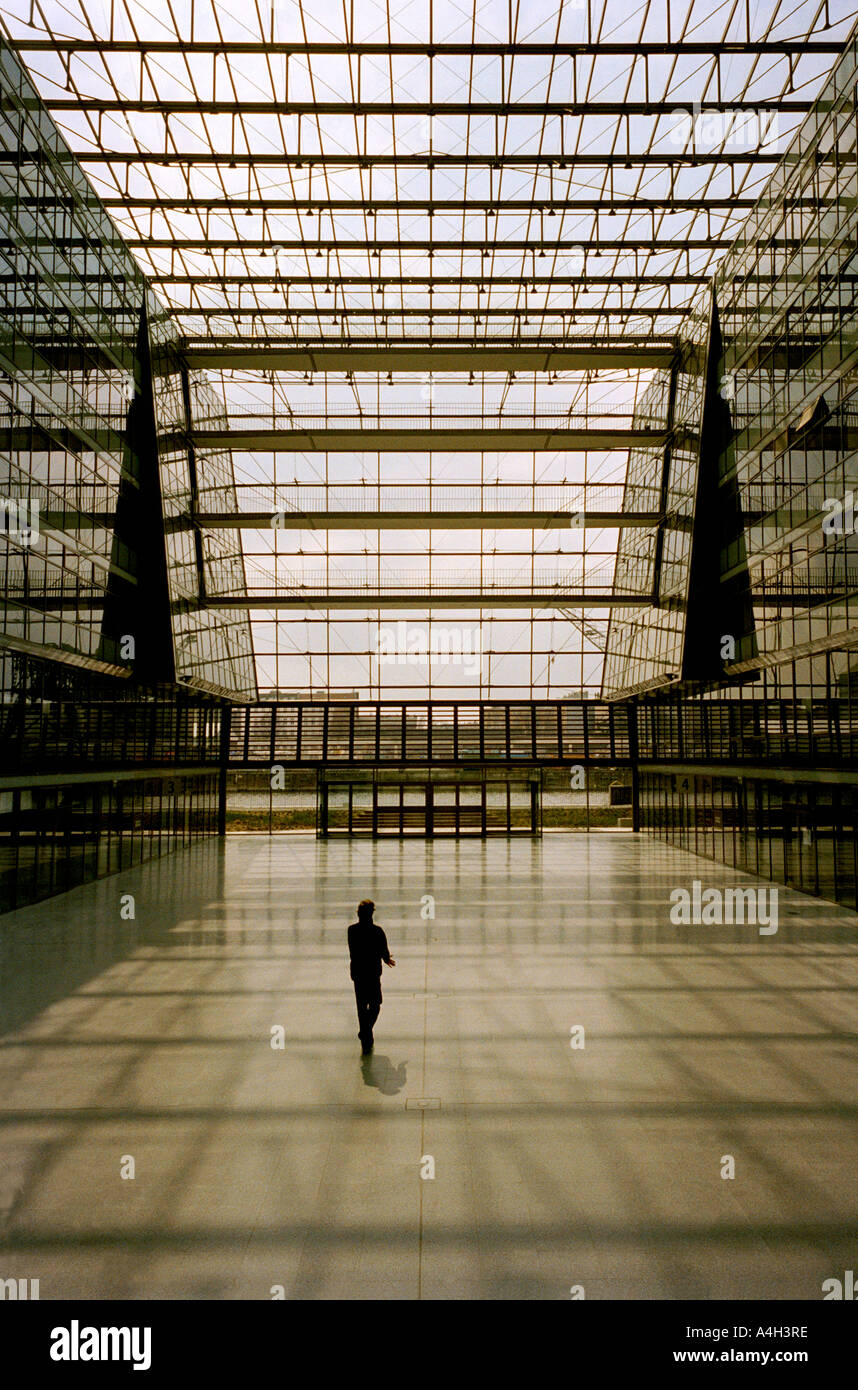 A man walking inside a steel and glass building in Berlin, Germany ...