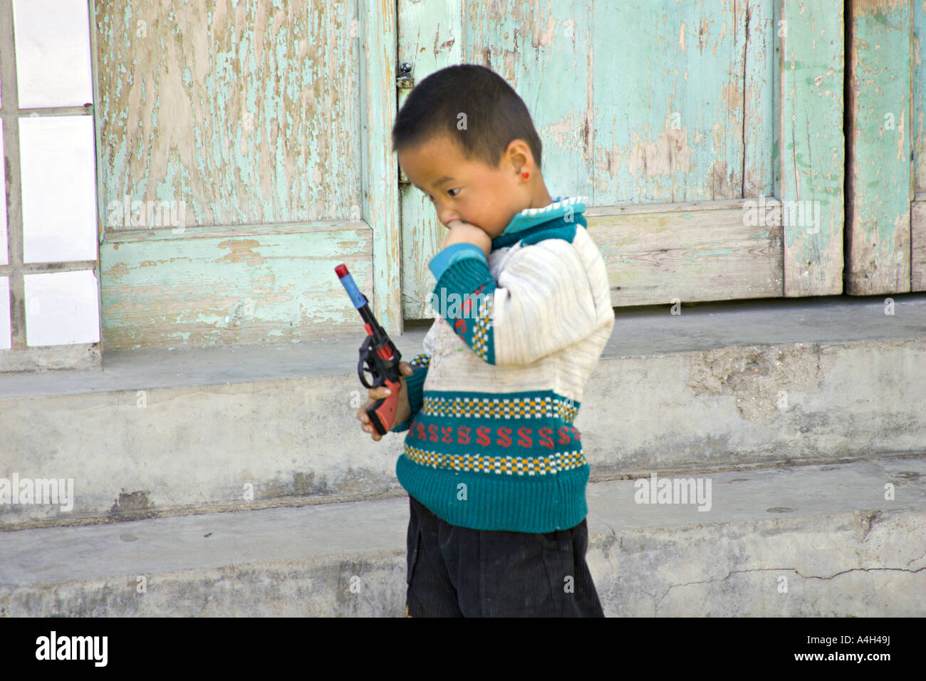 CHINA GREAT WALL Young Chinese boy playing with a toy gun in a rural ...