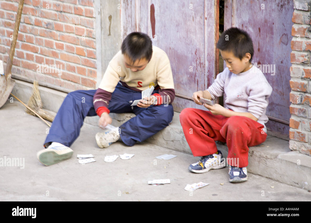 CHINA GREAT WALL Two young Chinese boys playing a card game outside ...