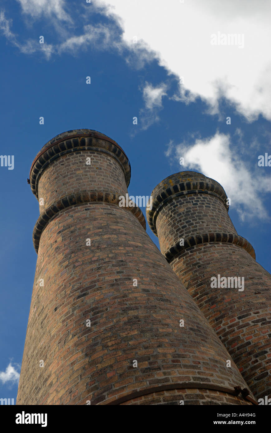 Twin chimneys of the Bovey Tracey pottery, against a summer blue sky ...