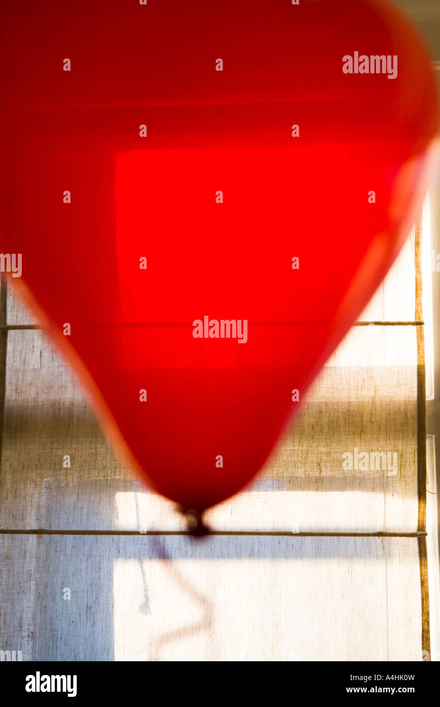 Red balloon against a window Stock Photo - Alamy