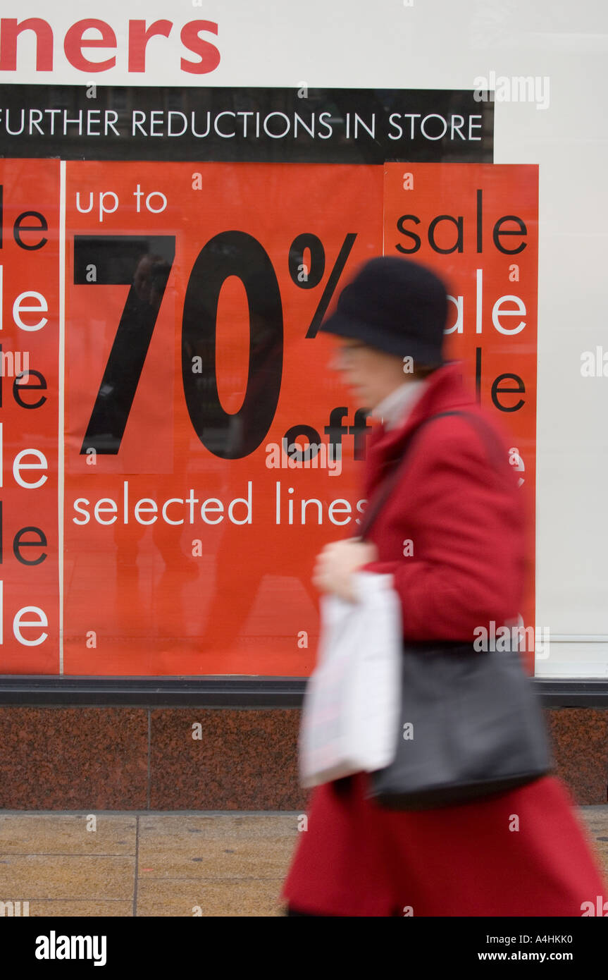 Large sale signs in shop window and shopper on British High Street ...