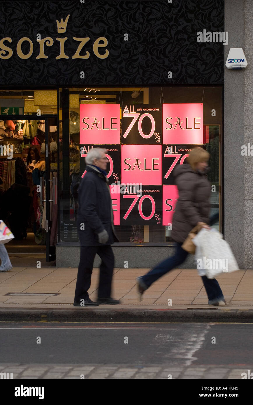 Large sale signs in shop window and shoppers on British High Street ...