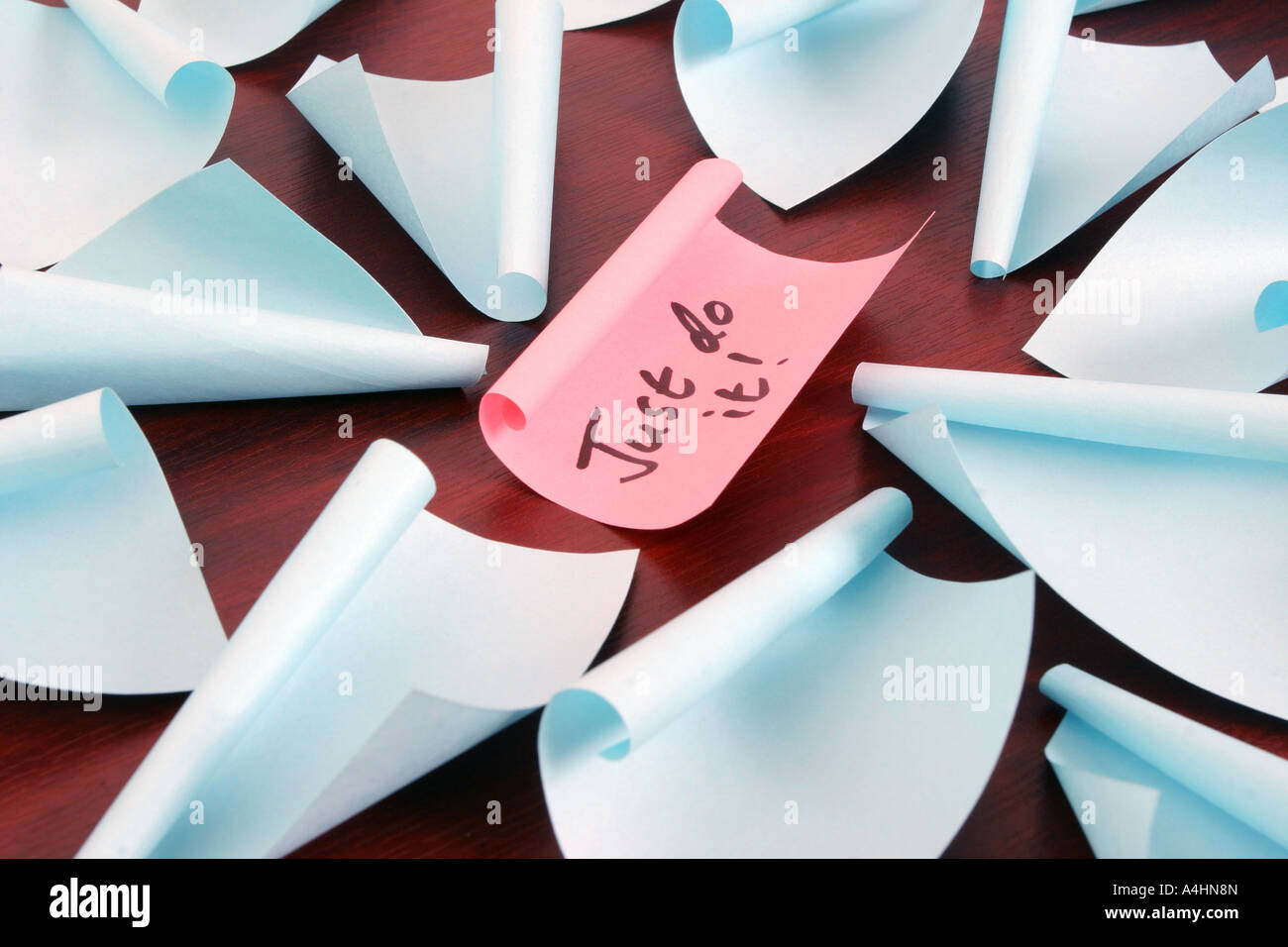 A pink post-it note with “Just do it!” written on it surrounded by ...