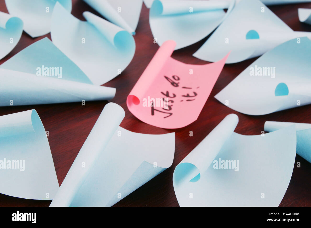 A pink post-it note with “Just do it!” written on it out of focus ...