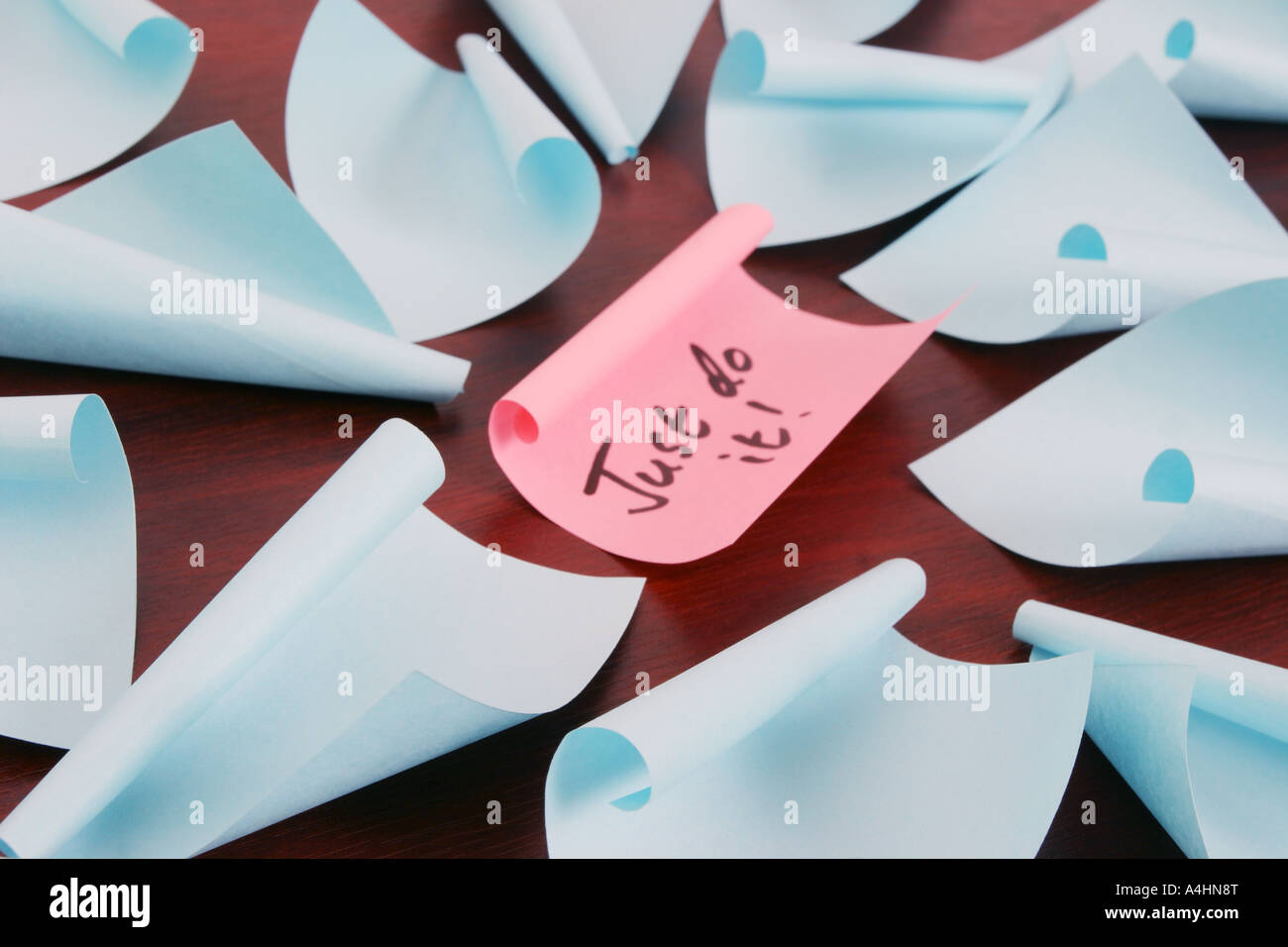 A pink post-it note with “Just do it!” written on it out of focus ...