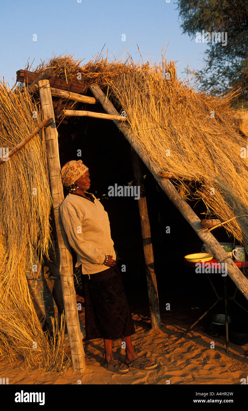 Bushman San woman outside her grass homestead Kalahari Northern Cape ...