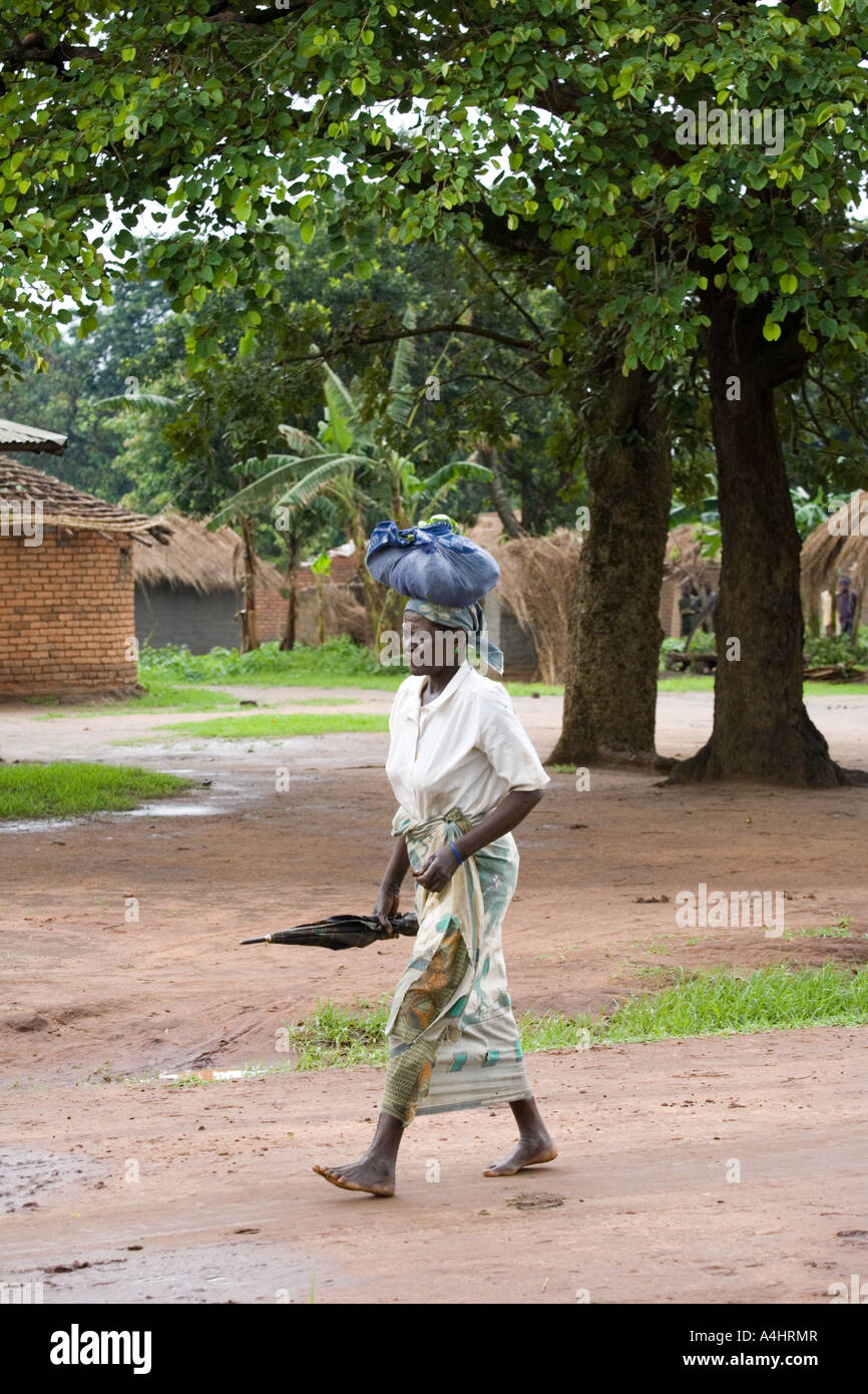 A woman carrying a bundle on her head in the village of Khoswe, Malawi ...