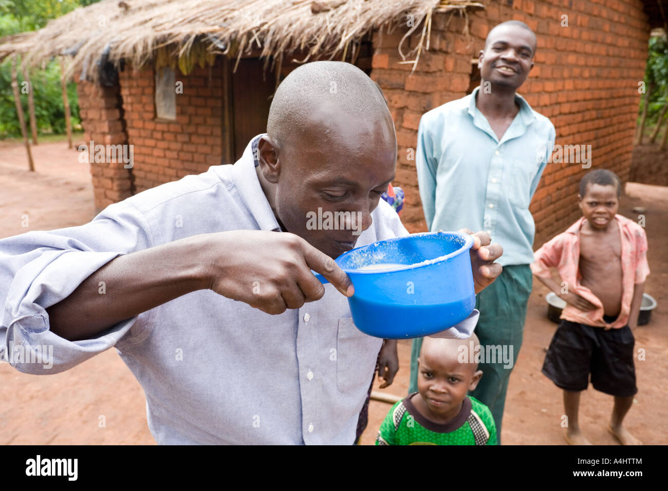 Cameron demonstrating thobwa, a drink made from maize and water, in the ...