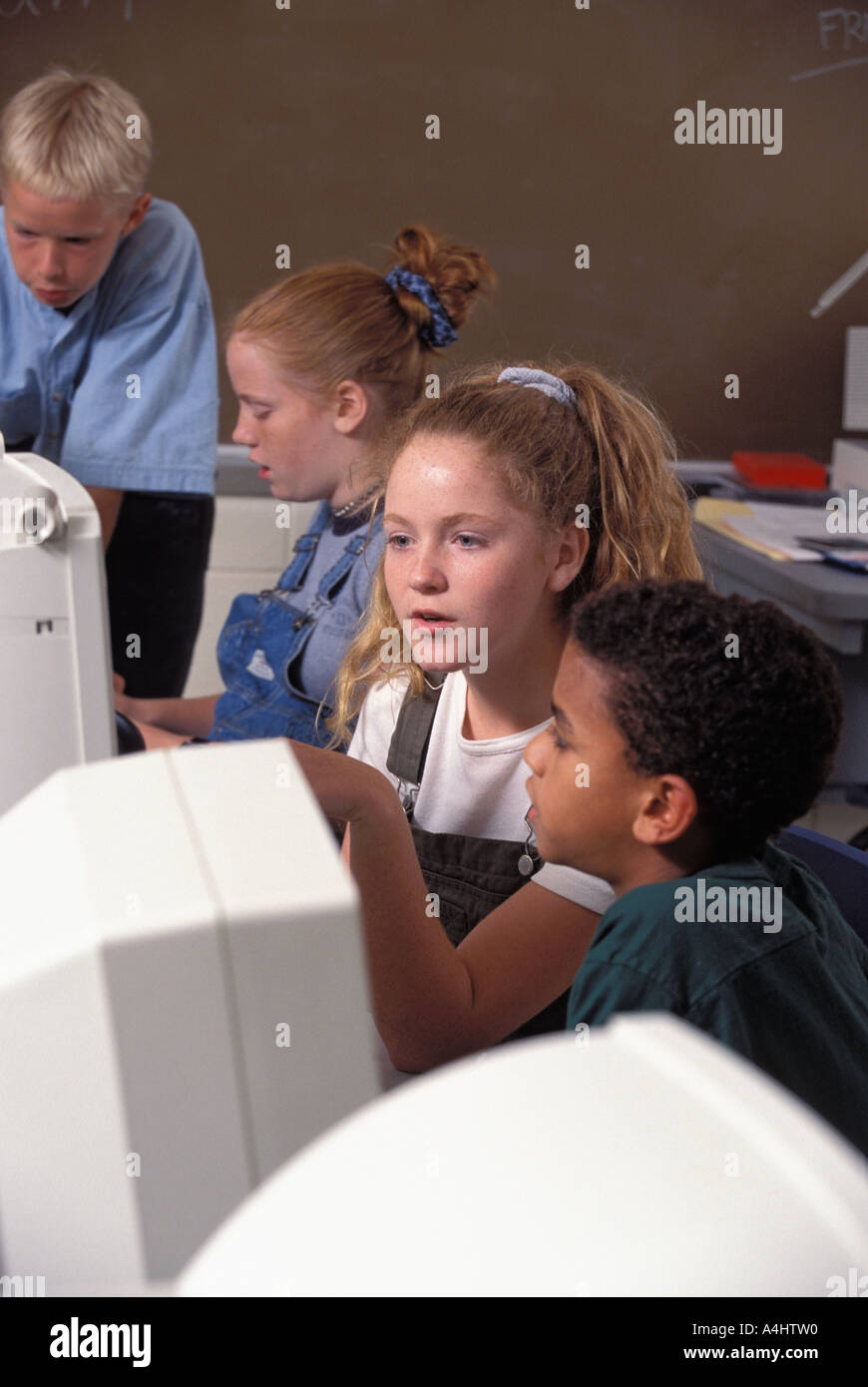 African American and Caucasian students in middle school computer room ...