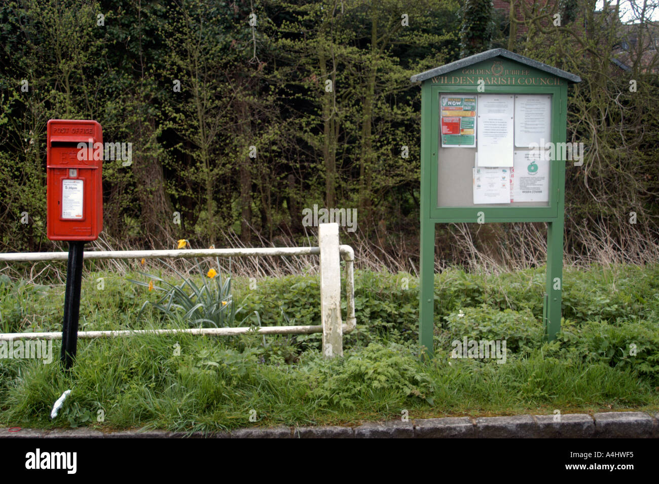 red village letter box or post box on a post in the countryside with ...