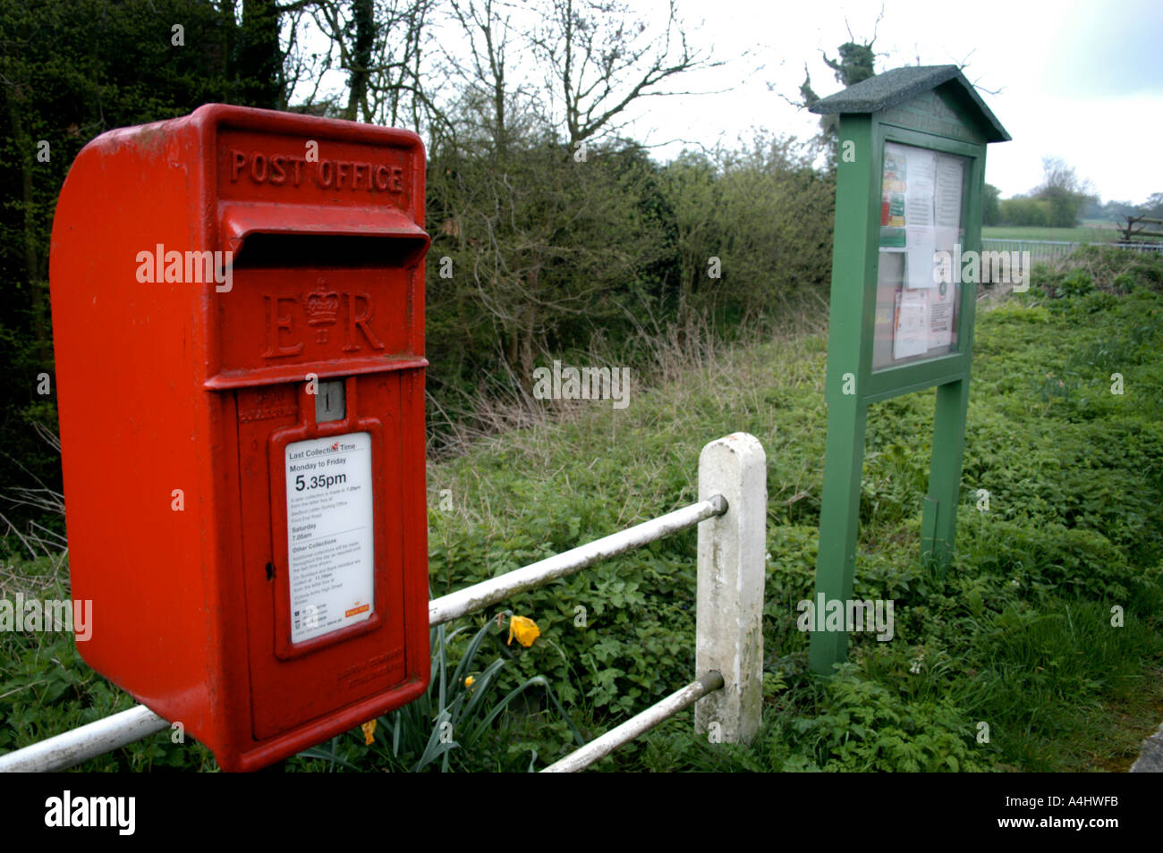 red village letter box or post box on a post in the countryside with ...