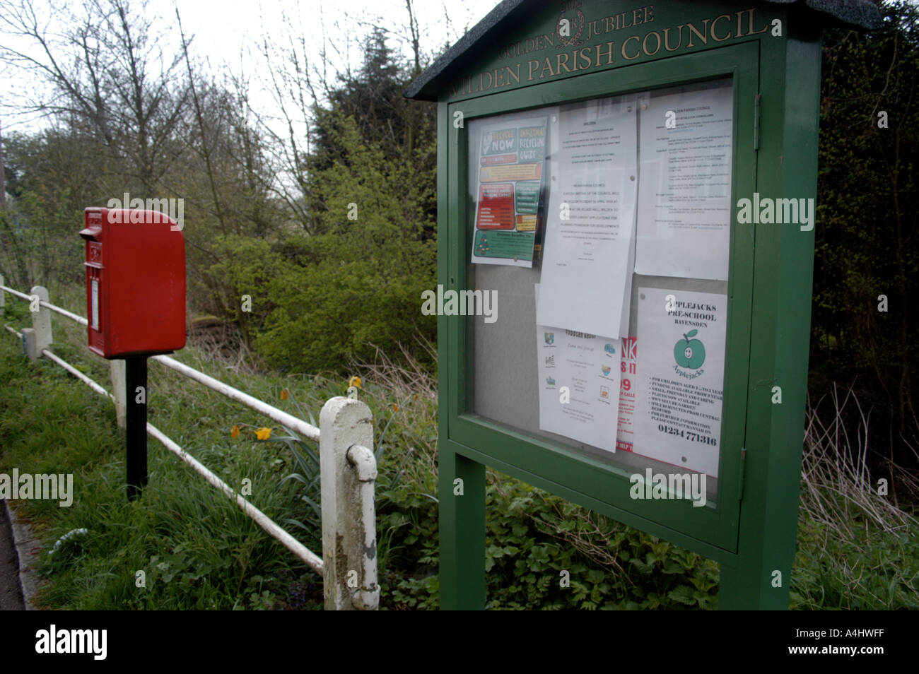 red village letter box or post box on a post in the countryside with ...
