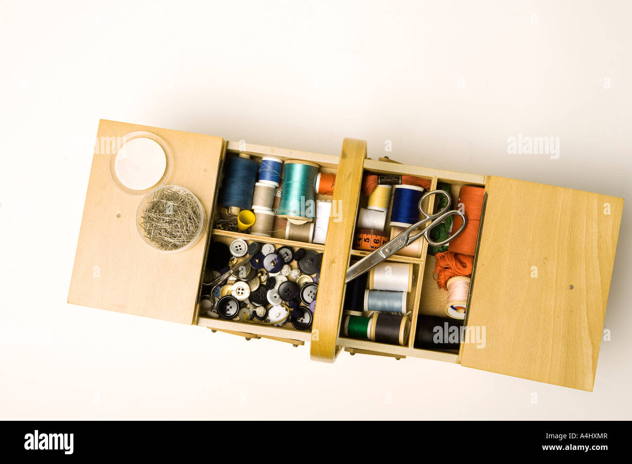 Looking down on a dress makers work box containing threads buttons and ...