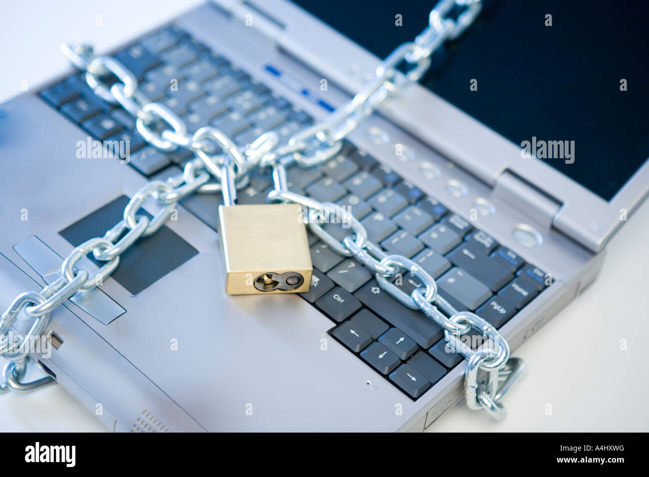 Portable computer wrapped in chains Stock Photo - Alamy