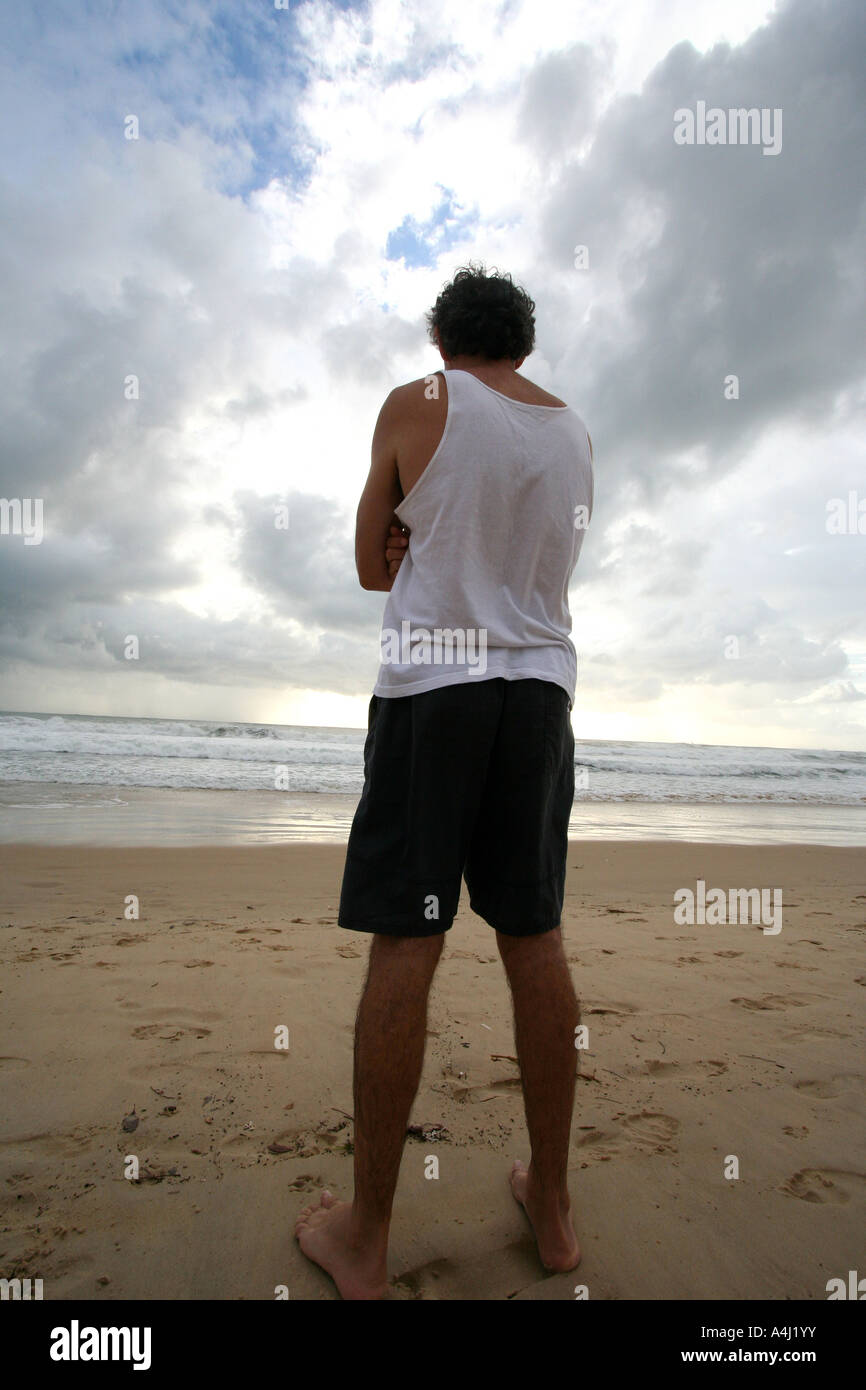 BACK VIEW OF MAN ON BEACH LOOKING OUT TO SEA VERTICAL BAPDA10024 Stock ...