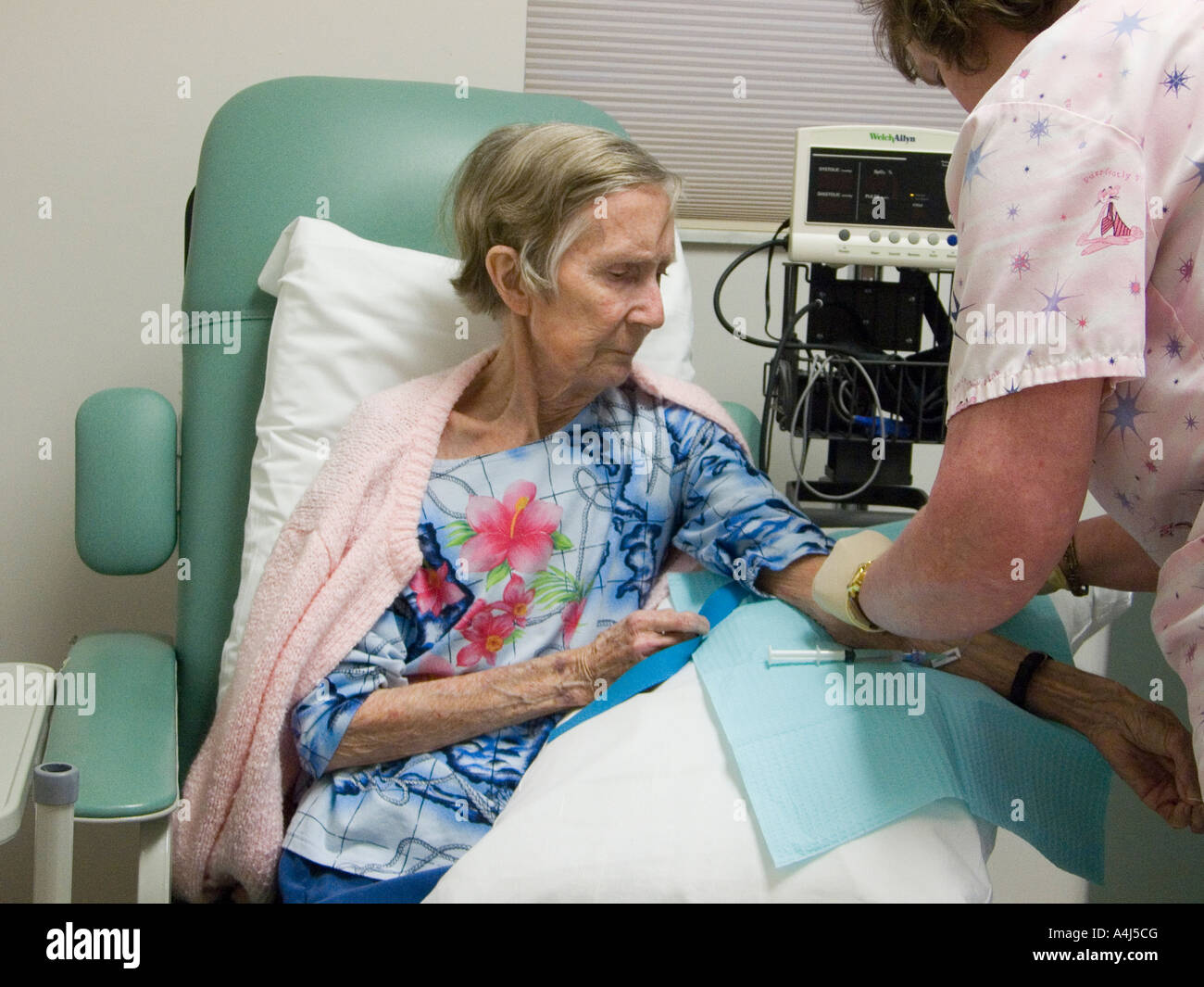nurse attaching blood iron solution drip to elderly woman patient in ...