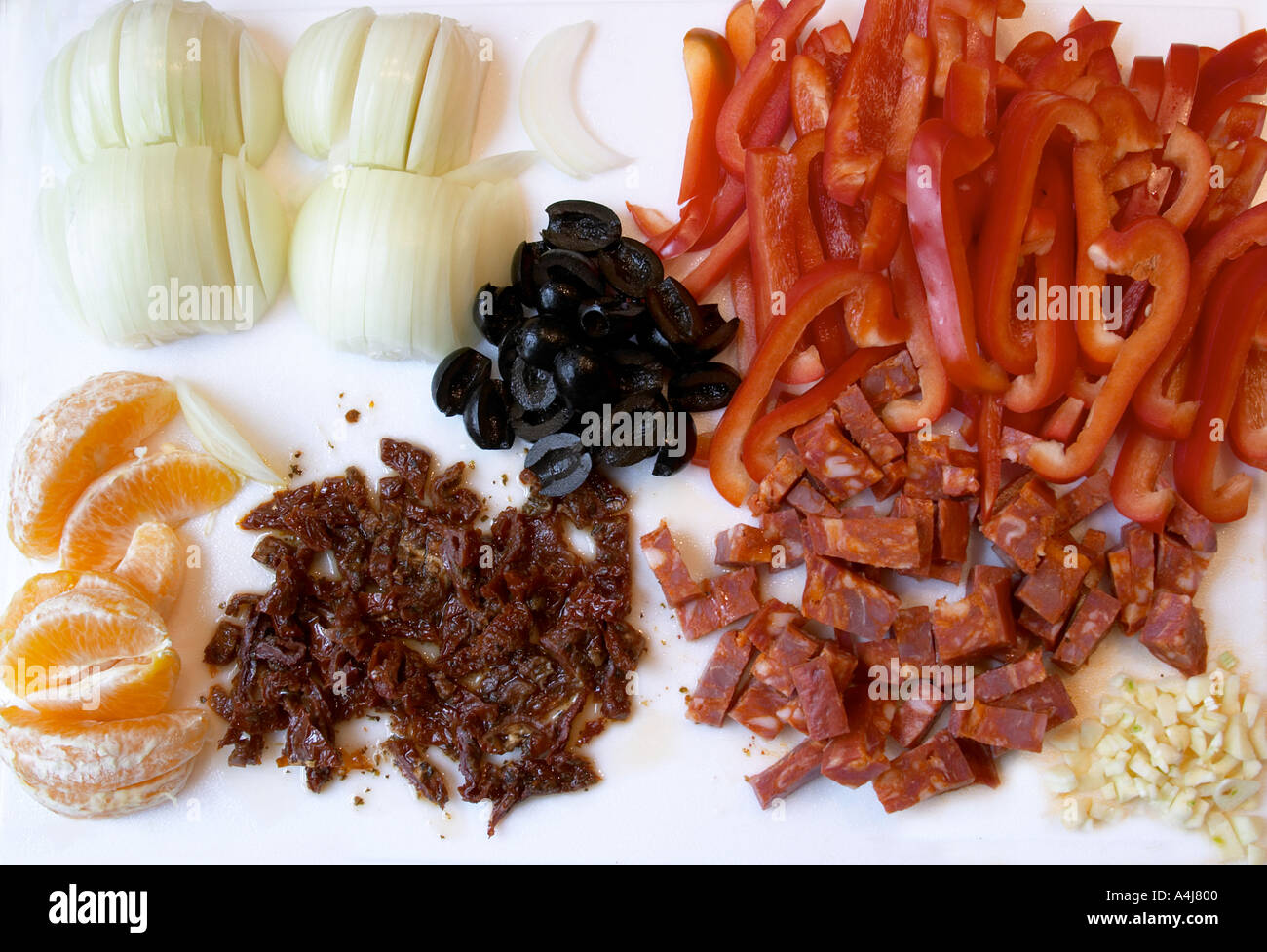 Food ingredients on a white chopping board. All items have been chopped ...