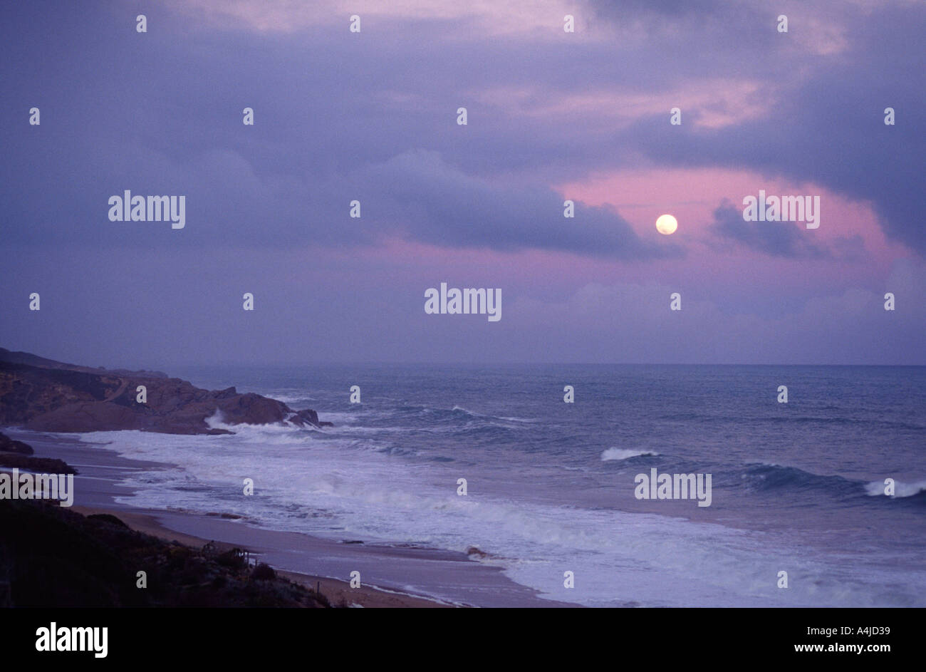 Full moon over sea with beach and rocks Stock Photo - Alamy