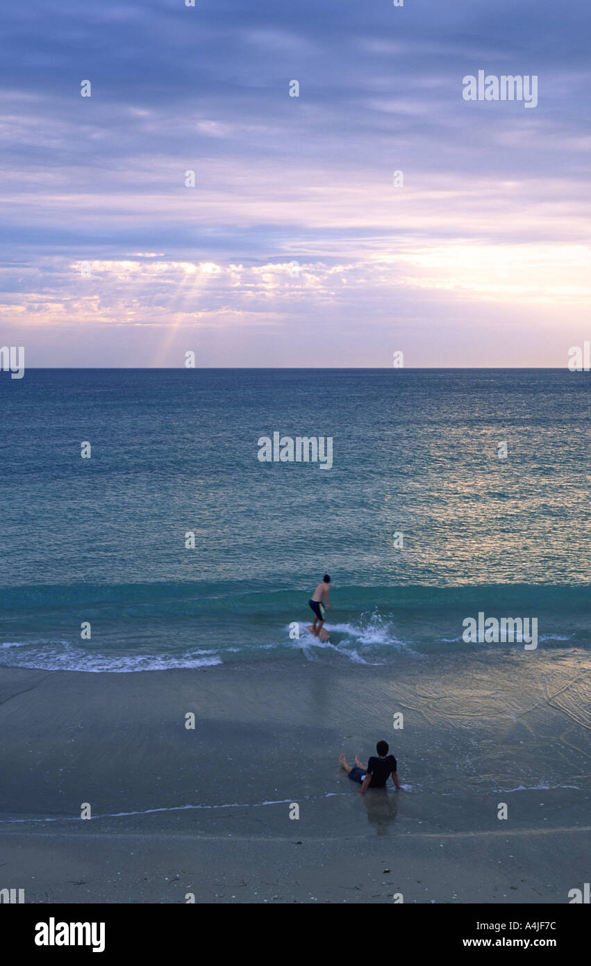 Boys playing at the beach with surfboard Stock Photo - Alamy