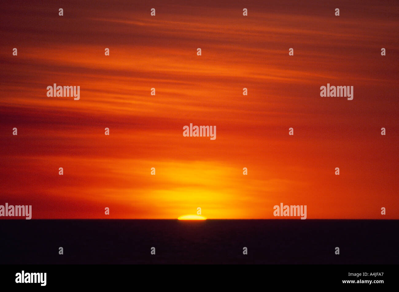 Setting sun and golden afterglow over the sea Stock Photo - Alamy