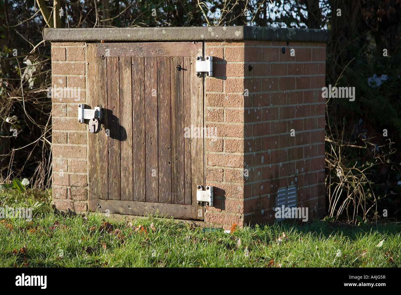 Small utility brick building with wooden door and padlock Stock Photo ...