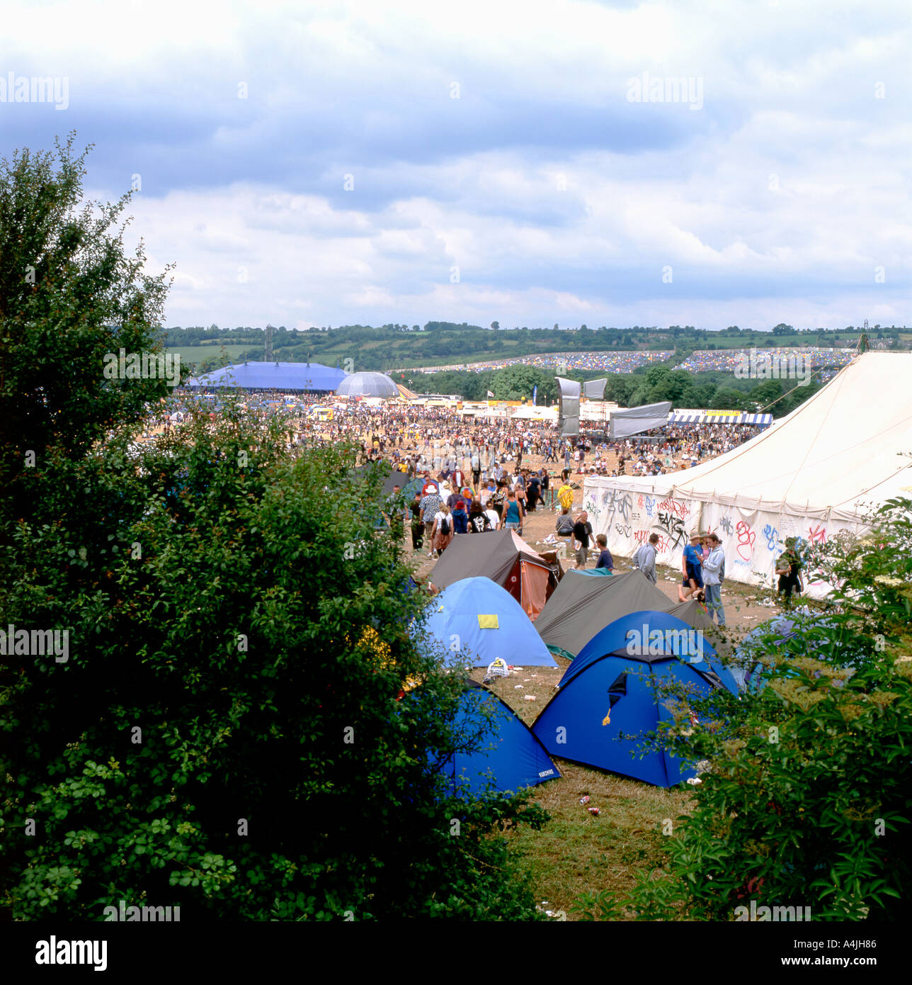 People, marquis tents in summer on the Worthy Farm camping site at ...