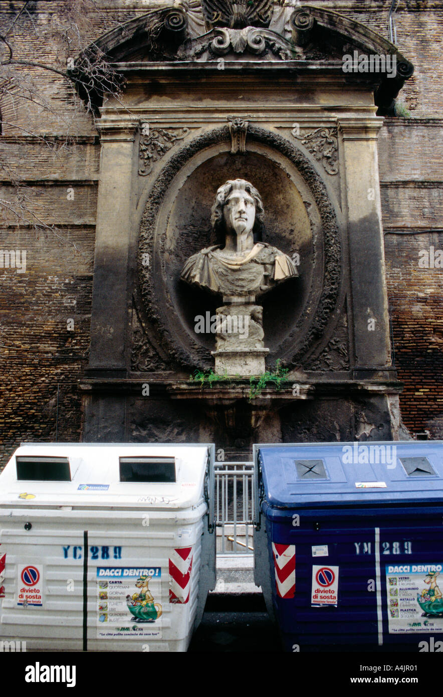 Rome. Italy. Recycling bins stand against a huge bust in the Aurelian ...