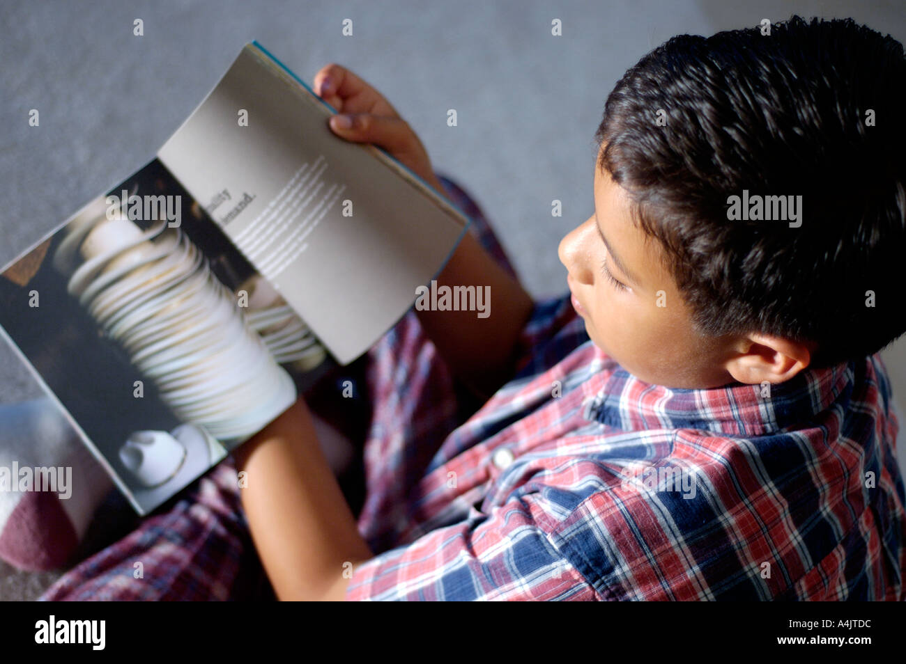 9 years old boy flipping over a page in a book Stock Photo - Alamy