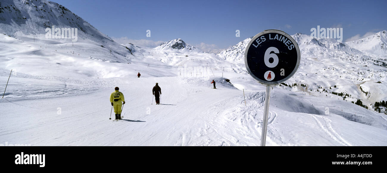 Les Laines blue run piste sign above Belle Plagne in Savoie with skiers ...
