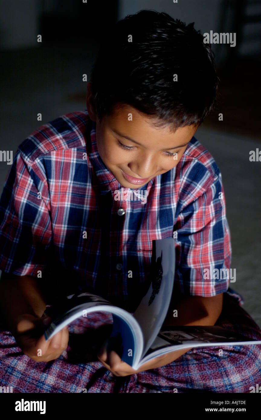 9 years old boy flipping over a page in a book Stock Photo - Alamy