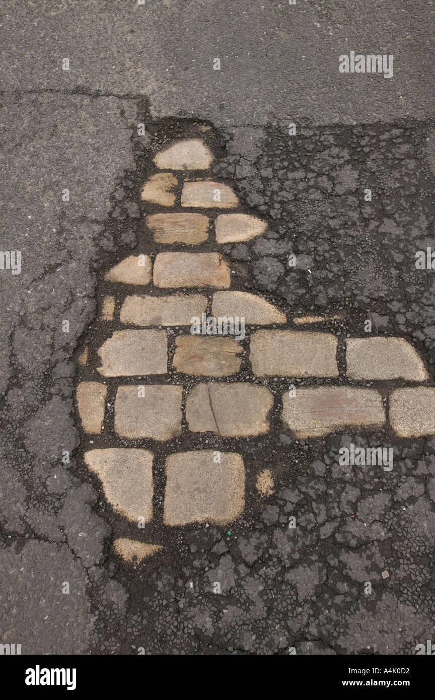 potholes in the road with old cobbled streets beneath Oldham Stock ...