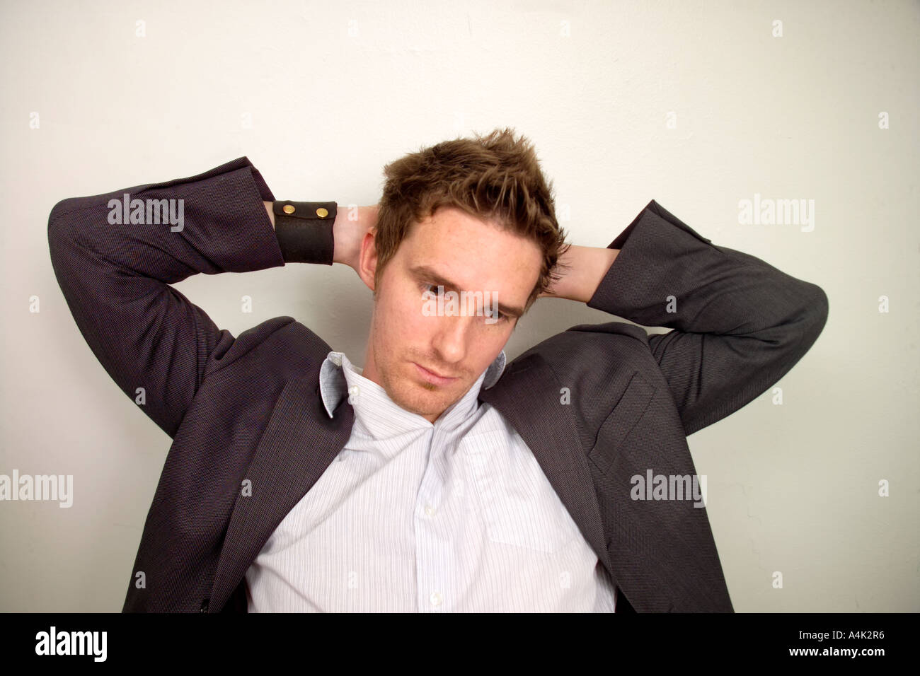 man sitting with hands behind his head Stock Photo - Alamy