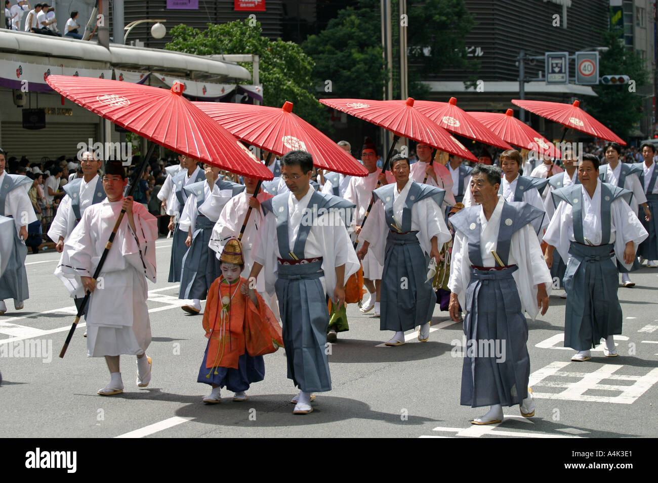 Period costumes and bright red umbrellas at the Gion Matsuri festival ...