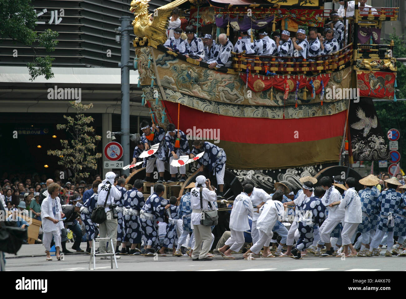 A boat shaped float is pushed and pulled during the Gion Matsuri ...