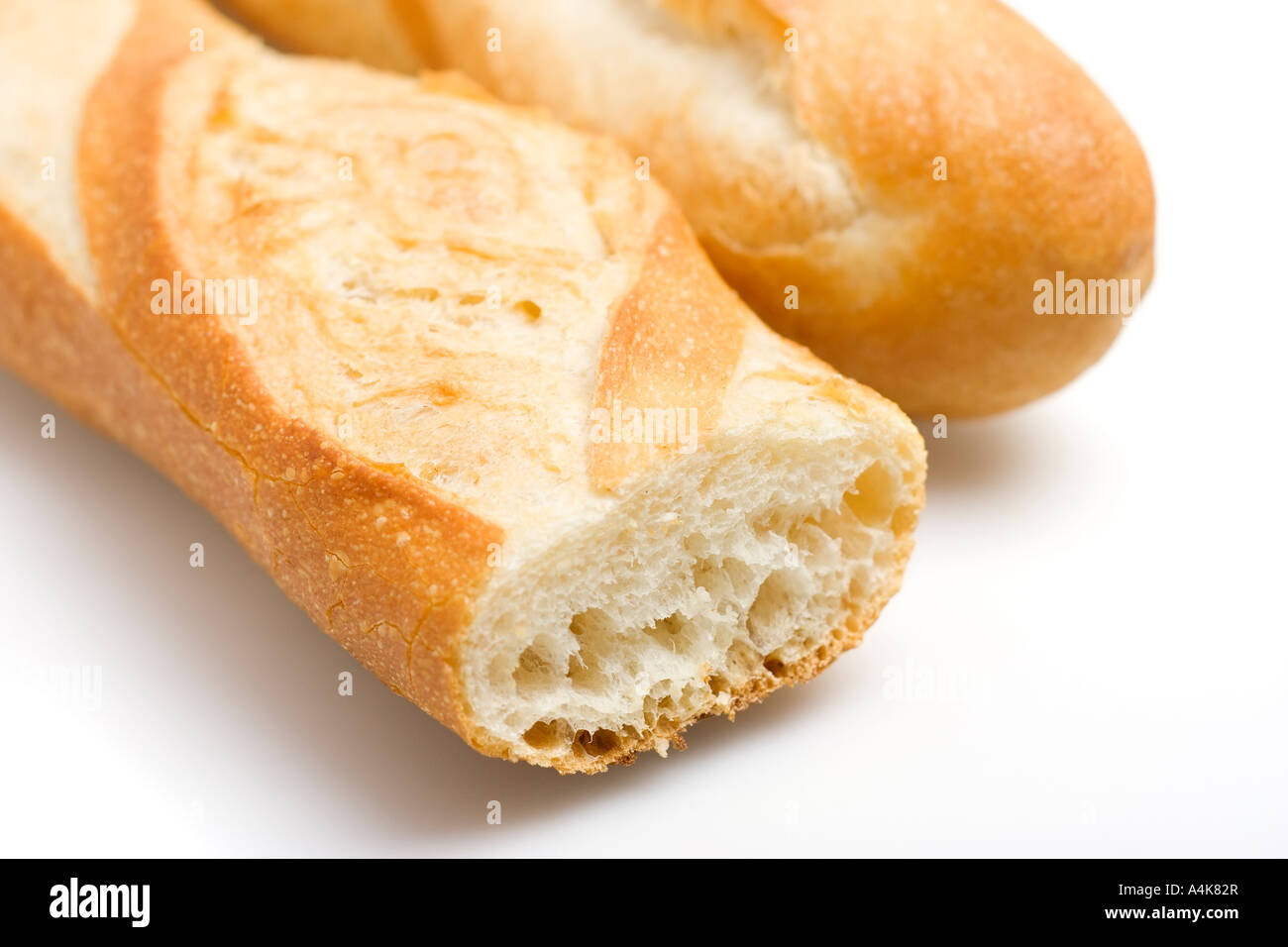 Closeup view of two french bread baguettes on a white background ...