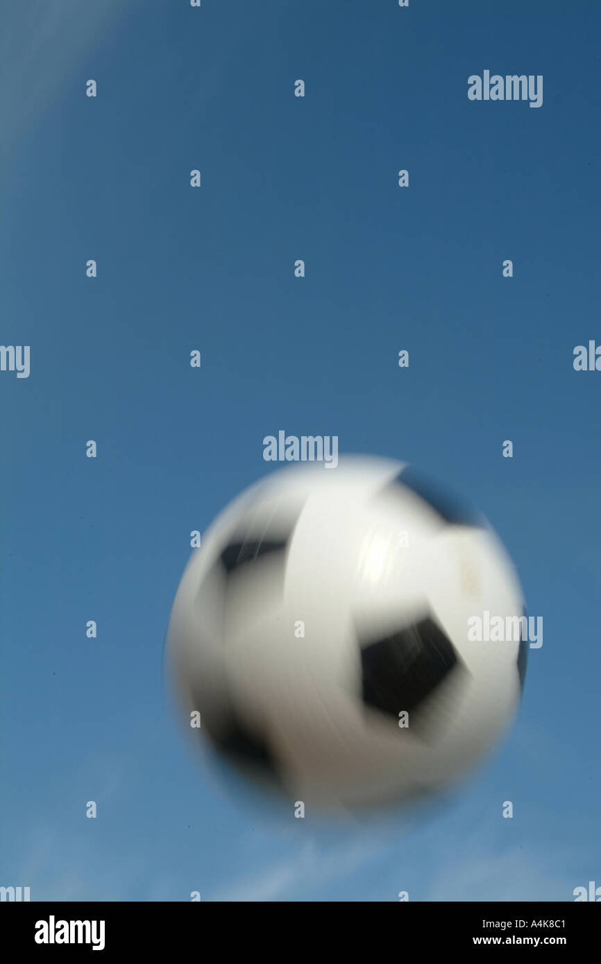 A football suspended in mid air against blue sky background Stock Photo ...